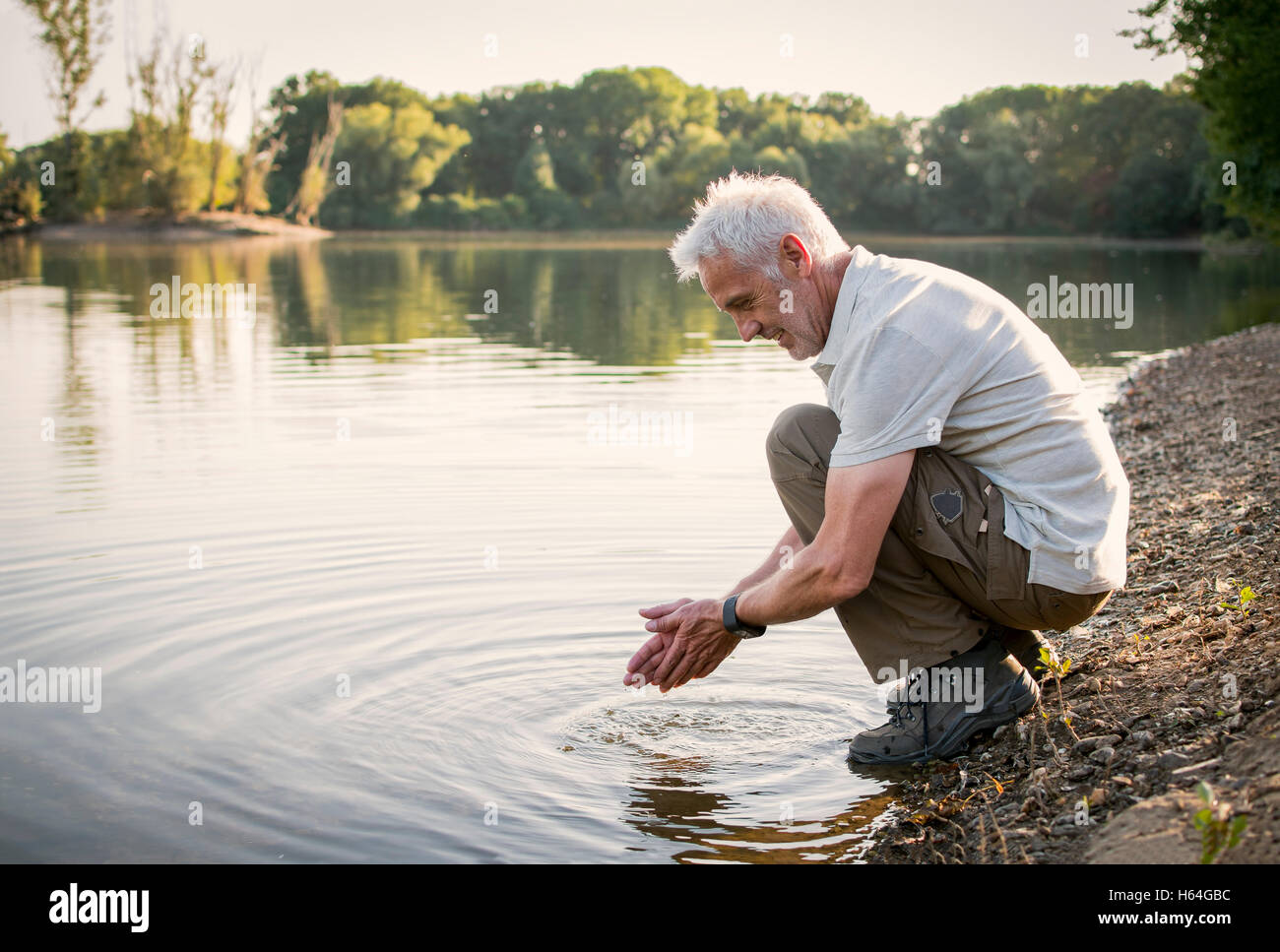Senior man refreshing at a lake Stock Photo - Alamy