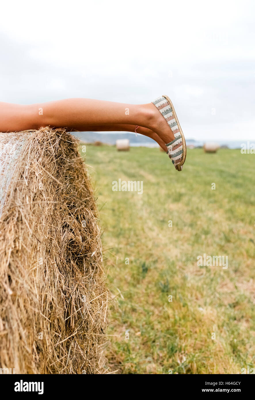 Legs of teenage girl lying on straw bale Stock Photo - Alamy