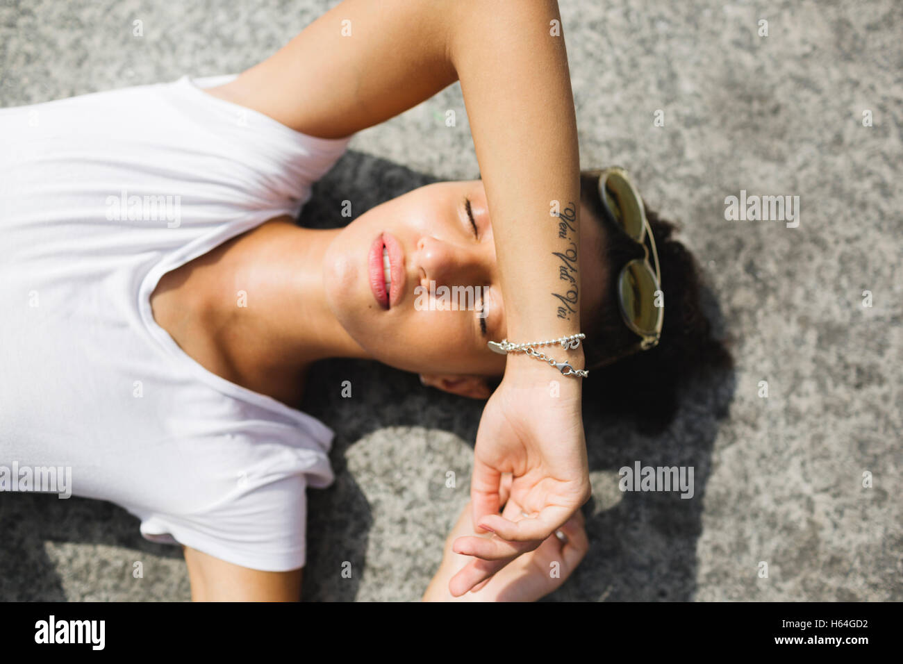 Relaxed young woman lying down enjoying the sunshine Stock Photo - Alamy