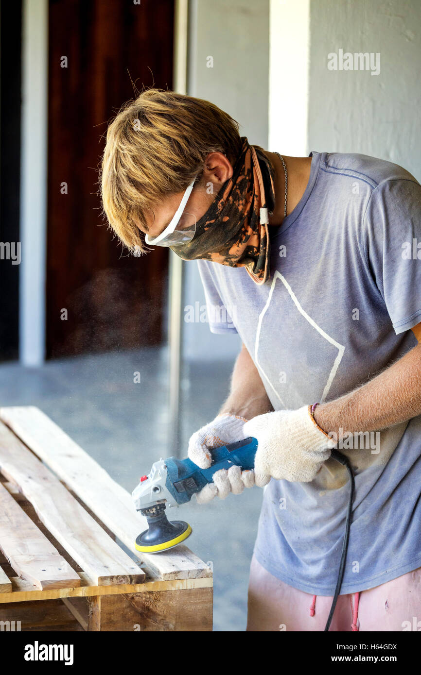 Man sanding pallet with a random orbital sander Stock Photo - Alamy