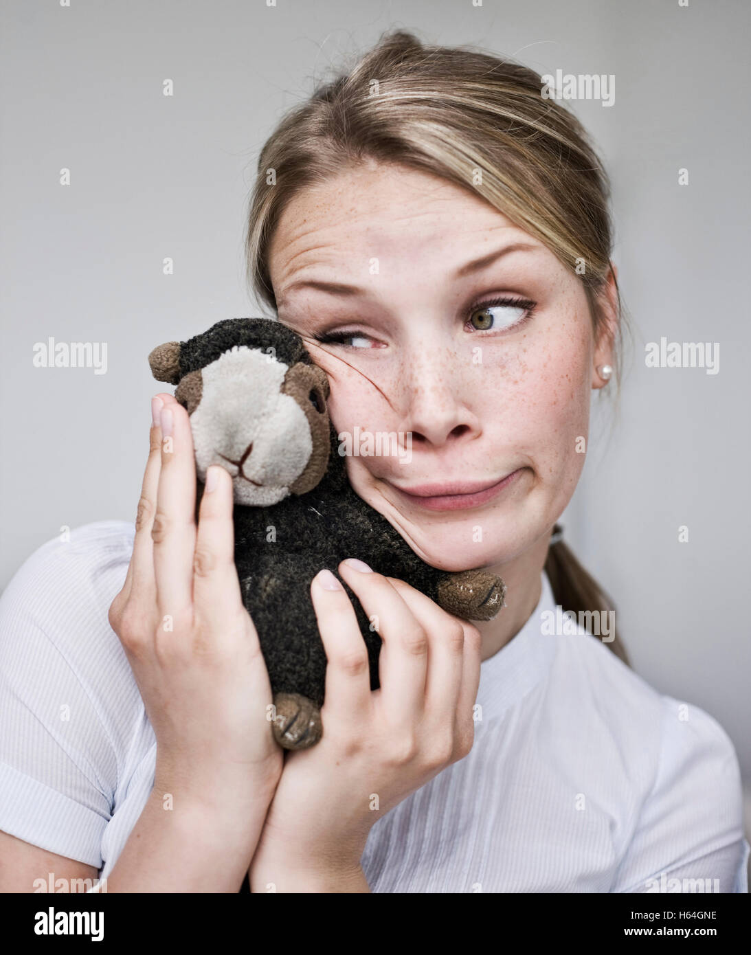 Young woman making a funny face holding cuddly toy Stock Photo - Alamy