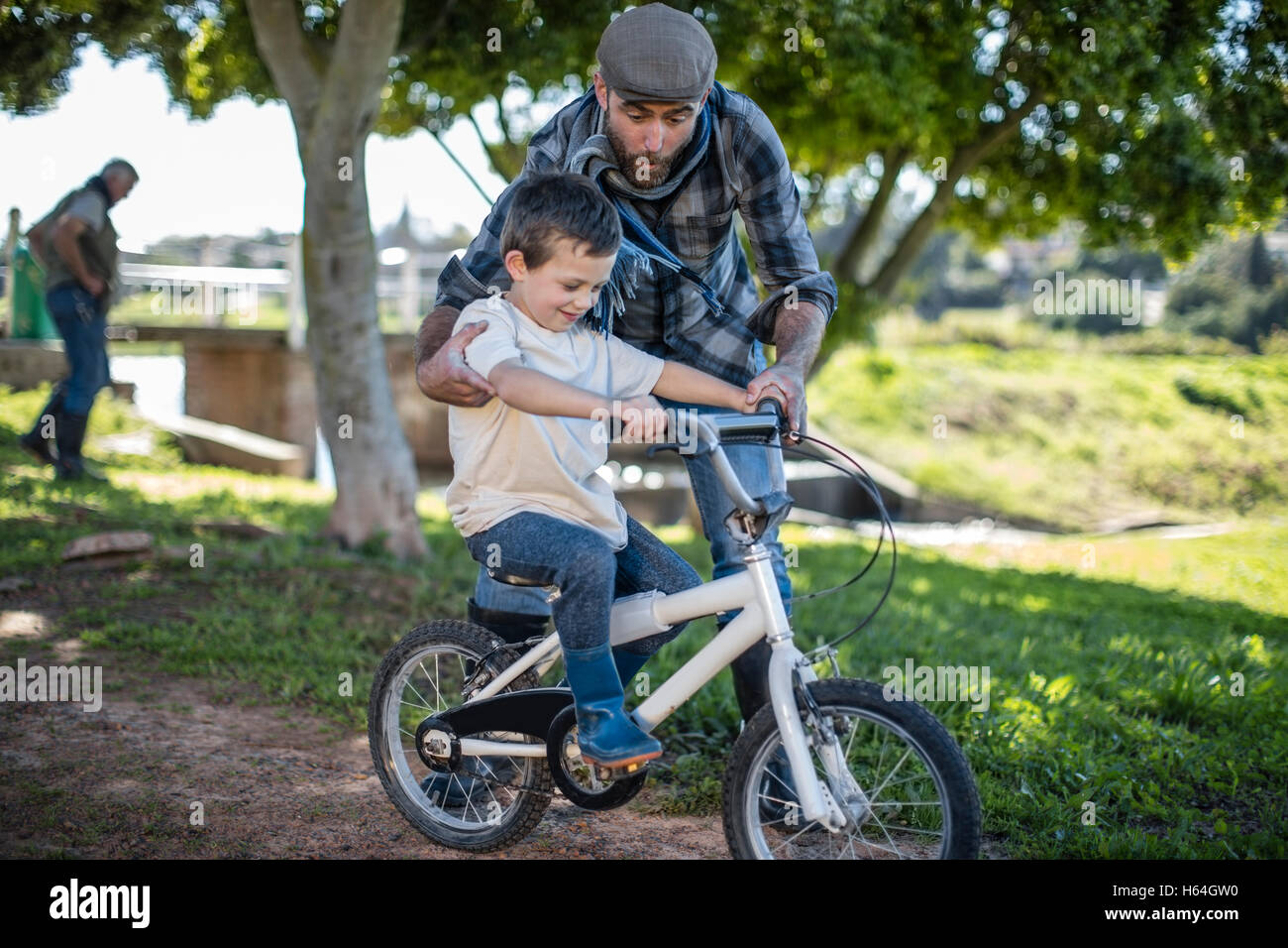 Father supporting son on bike Stock Photo - Alamy