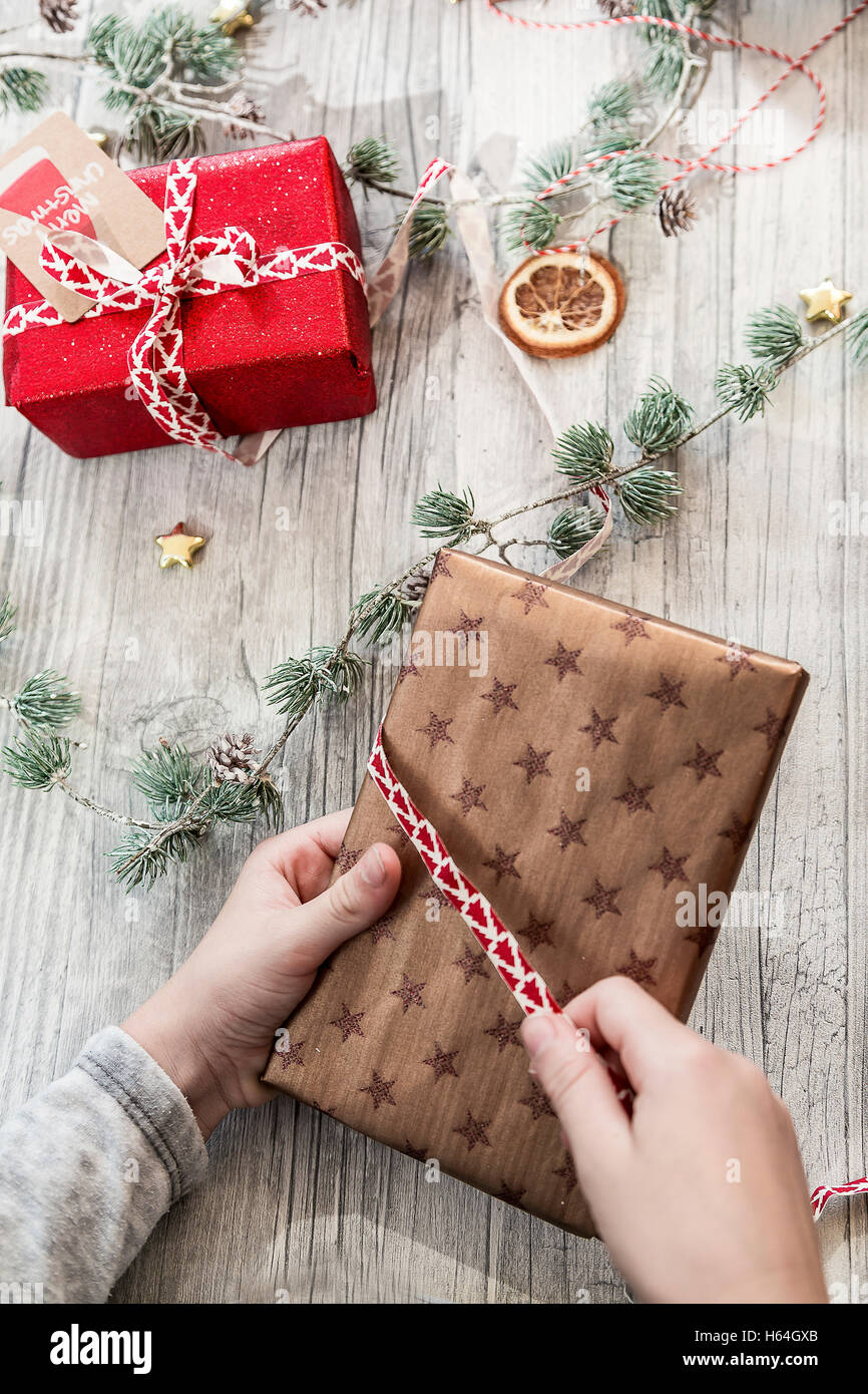 Hands of girl wrapping Christmas present Stock Photo - Alamy