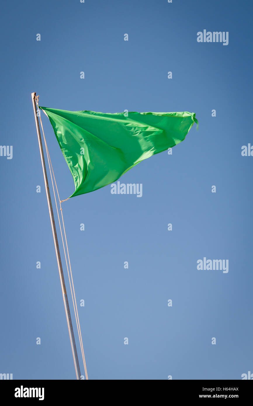 green flag in the beach Stock Photo - Alamy