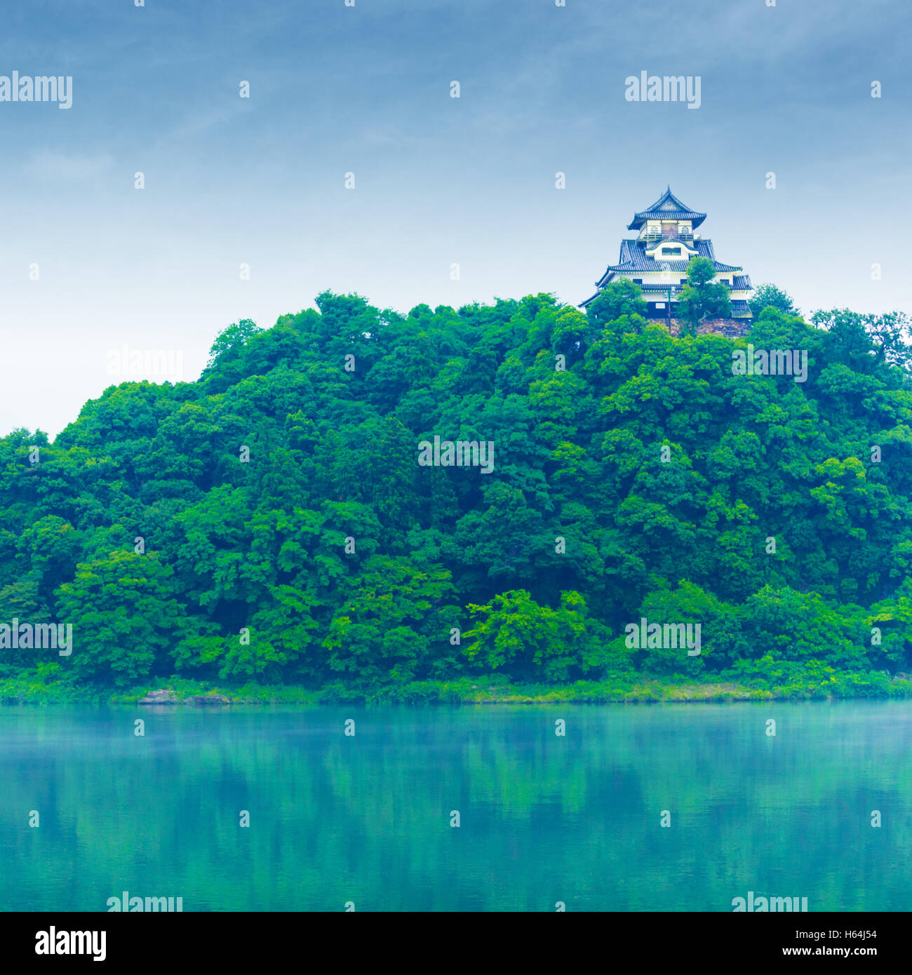 Stronghold of Inuyama Jo Castle high above Kiso River on blue sky day ...