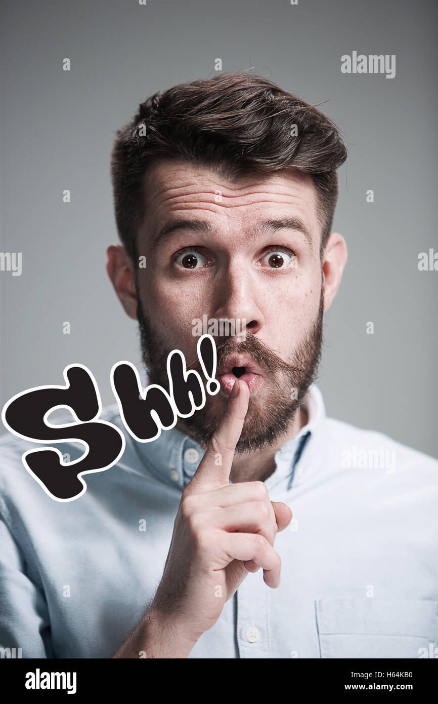Man is looking wary. Over gray background Stock Photo - Alamy