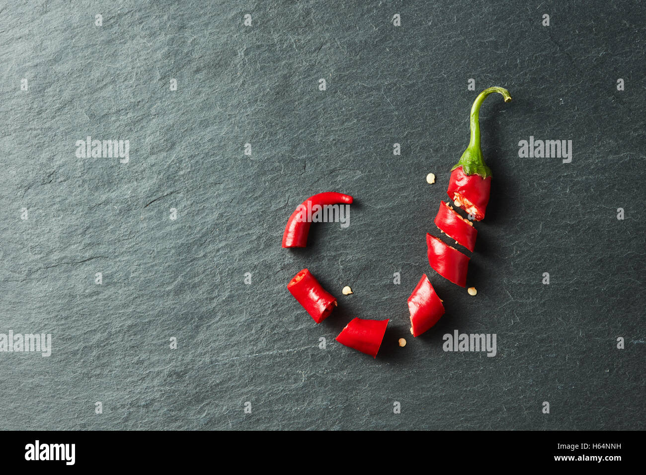 Chopped red chilli pepper over black concrete background Stock Photo ...