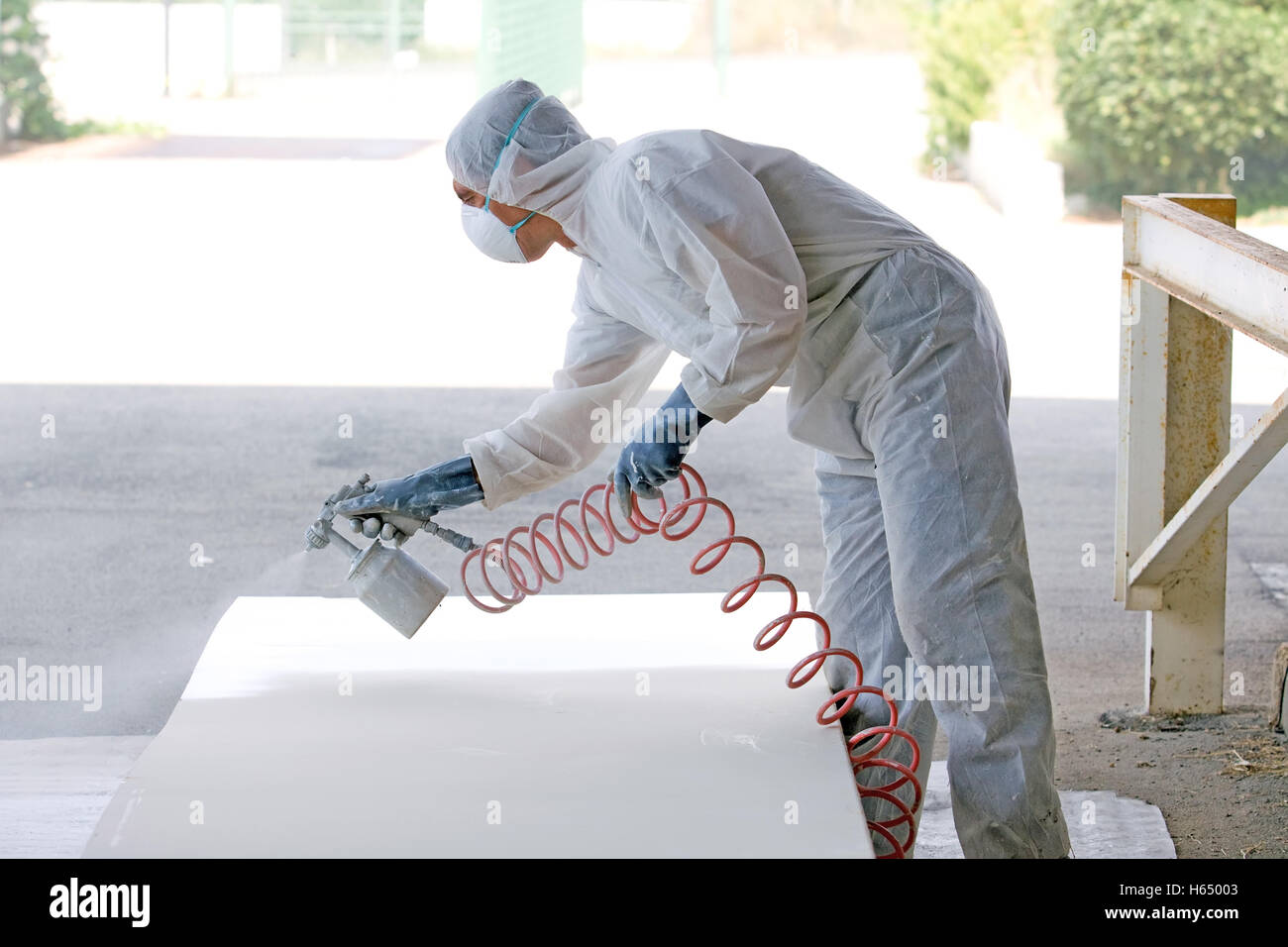 skilled worker painting industrial tool in a industry Stock Photo - Alamy