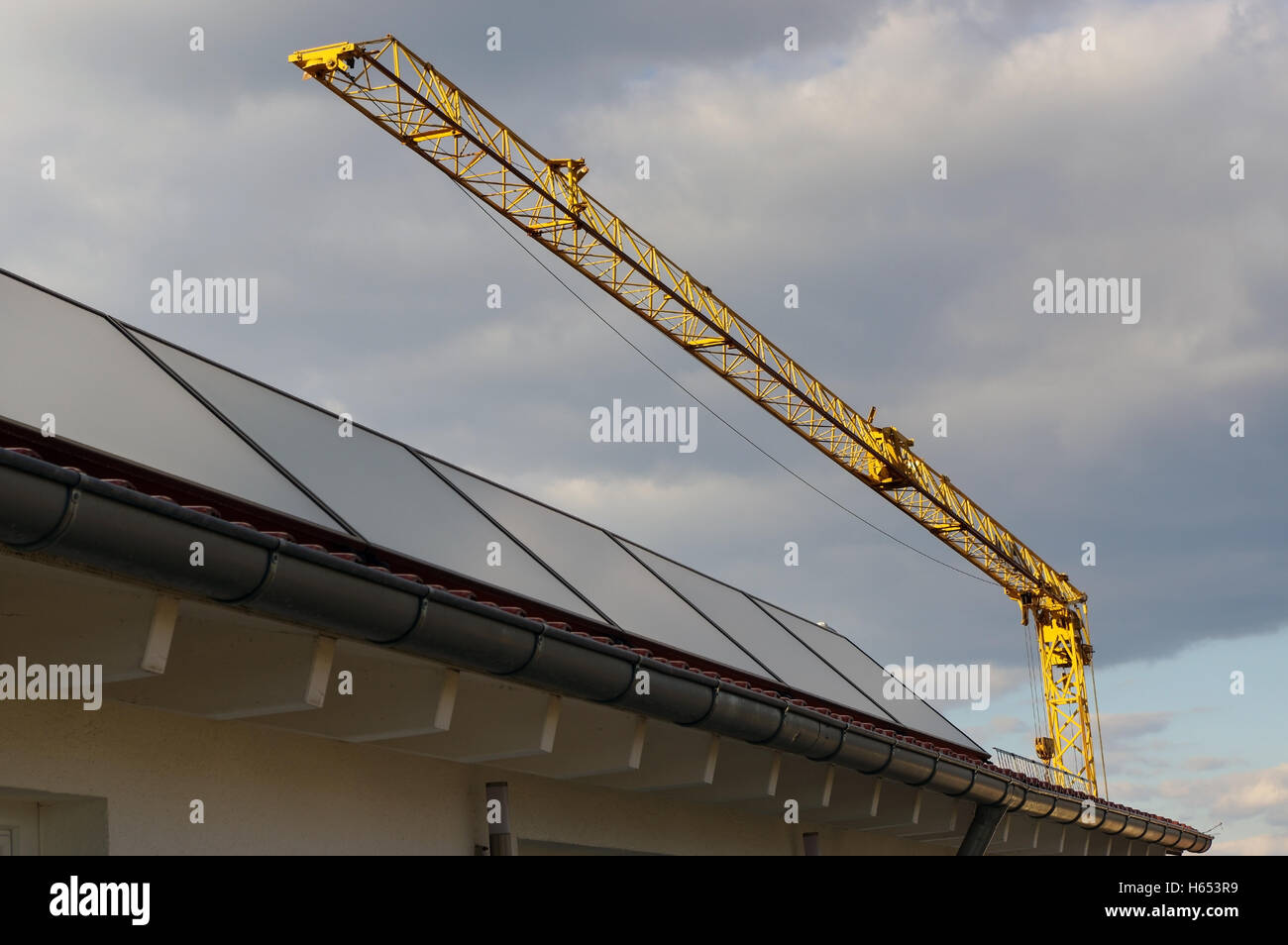 a Roof with solar photovoltaic panels photovoltaic and crane above it ...