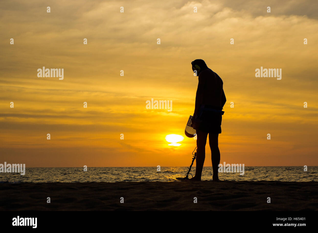 a treasure hunter with Metal detector on sunset on the beach Stock ...