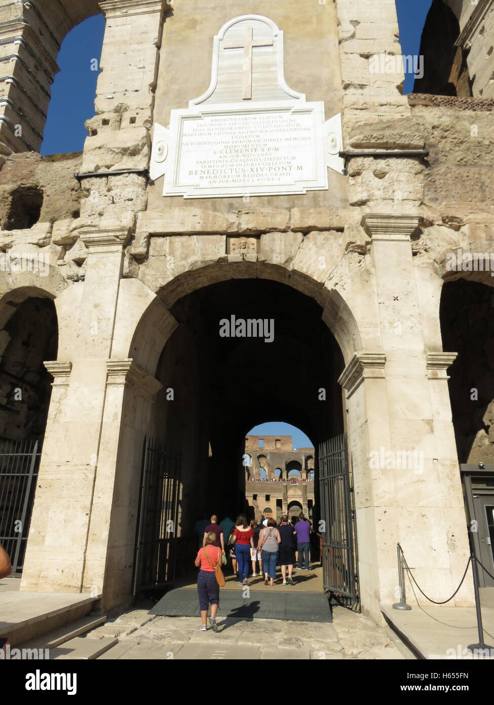 The main entrance to the Colosseum with tourists walking through ...
