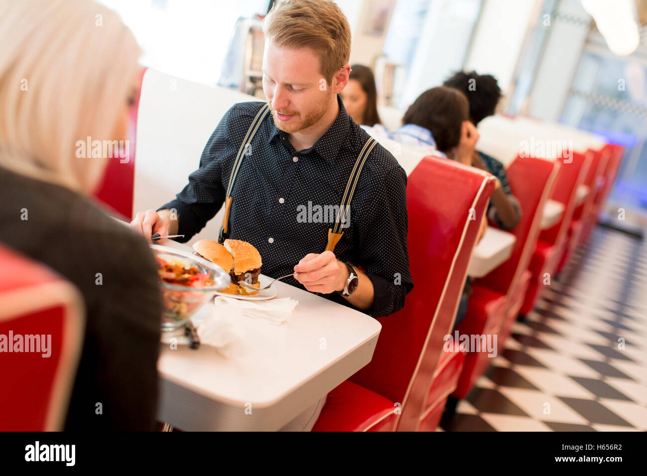 Friends eating fast food at the table in the diner Stock Photo - Alamy