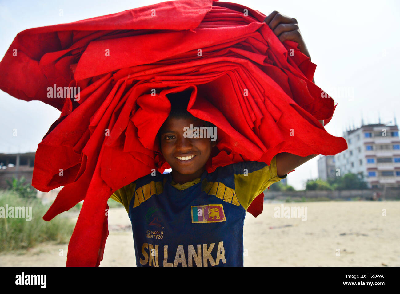 A Bangladeshi child laborer carries dry leather on his head in Dhaka ...