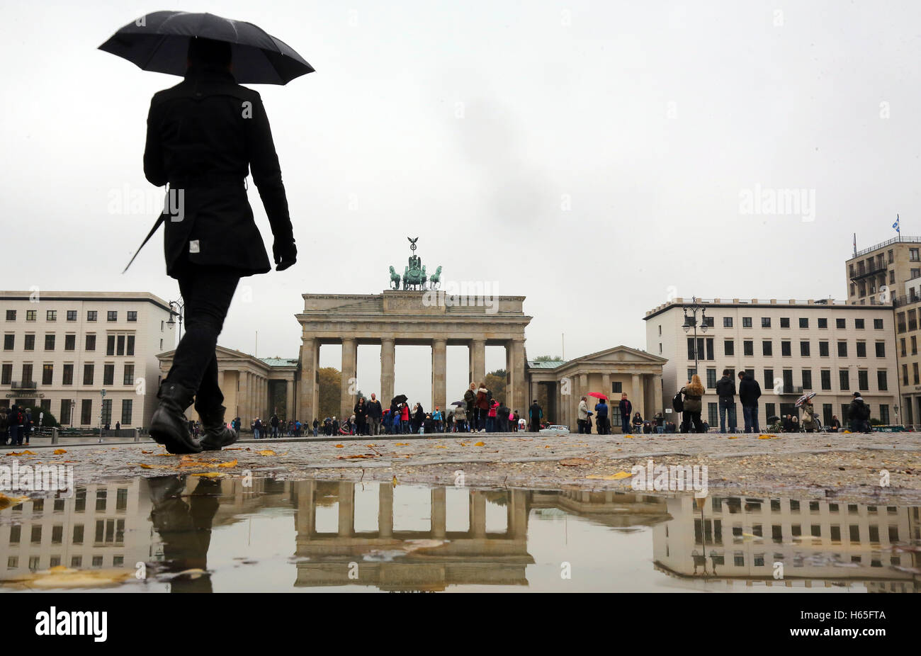 Berlin, Germany. 25th Oct, 2016. Pedestrians walk past puddles in ...