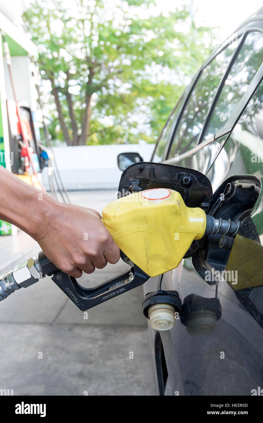 Pumping gas at gas pump. Closeup of man pumping gasoline fuel in car at ...