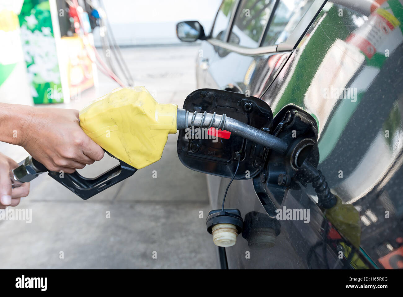 Pumping gas at gas pump. Closeup of man pumping gasoline fuel in car at ...