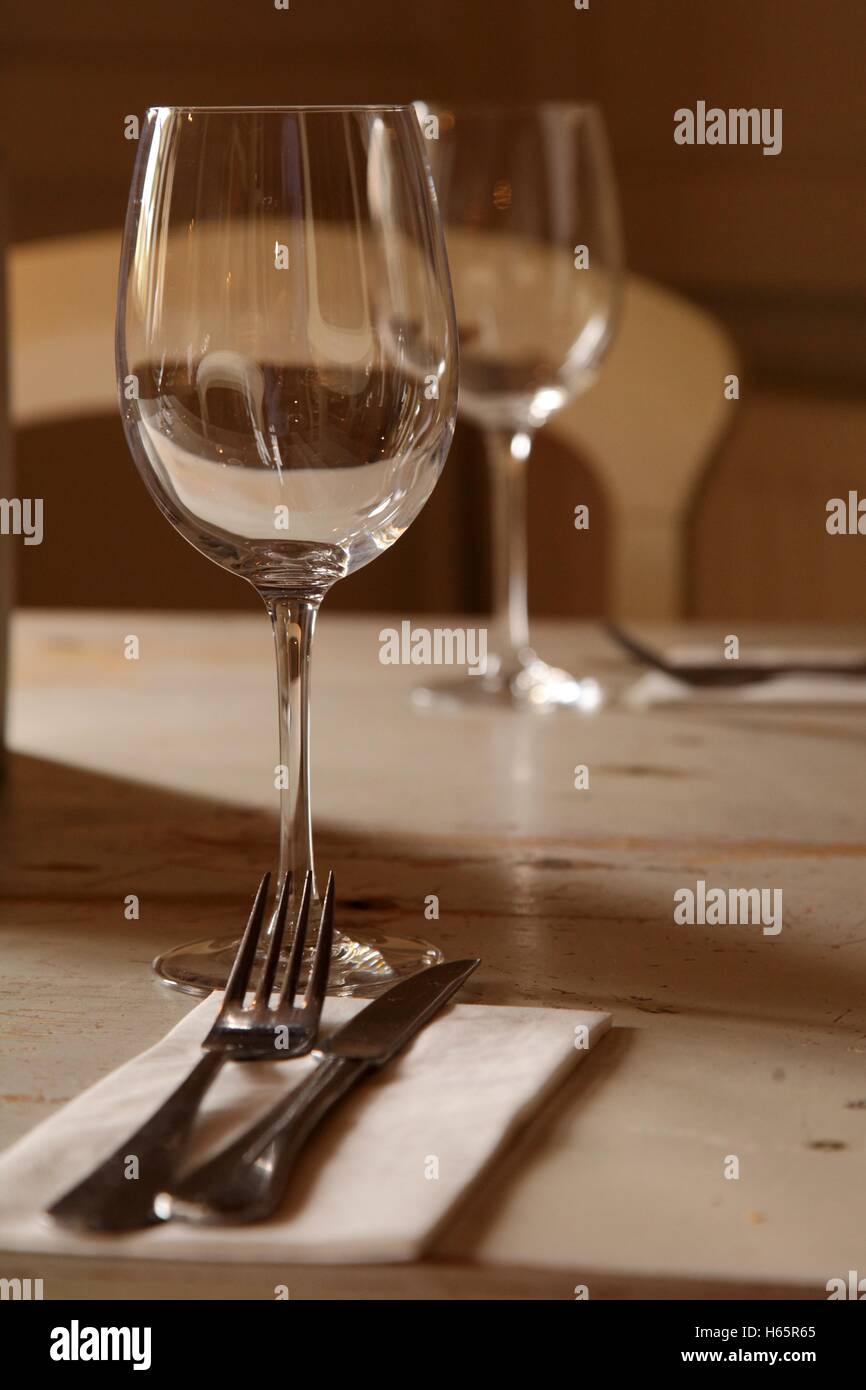 Two glasses, knifes and forks laid on a simple table, ready for lunch ...