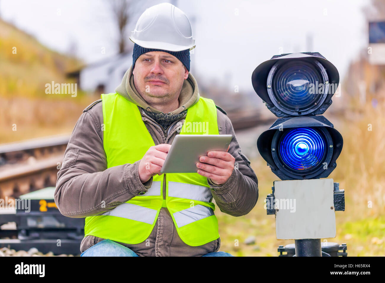 Railway employee with tablet PC near the warning lights Stock Photo - Alamy
