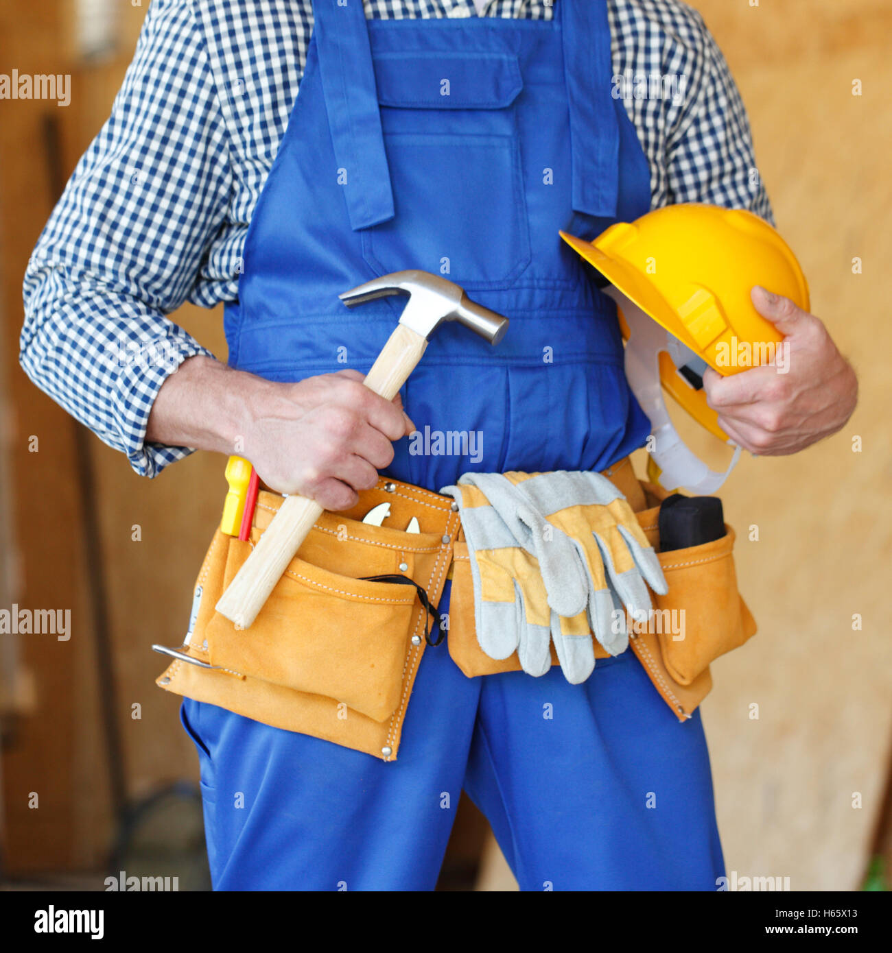 Construction worker with hammer in hand and tools at construction site ...
