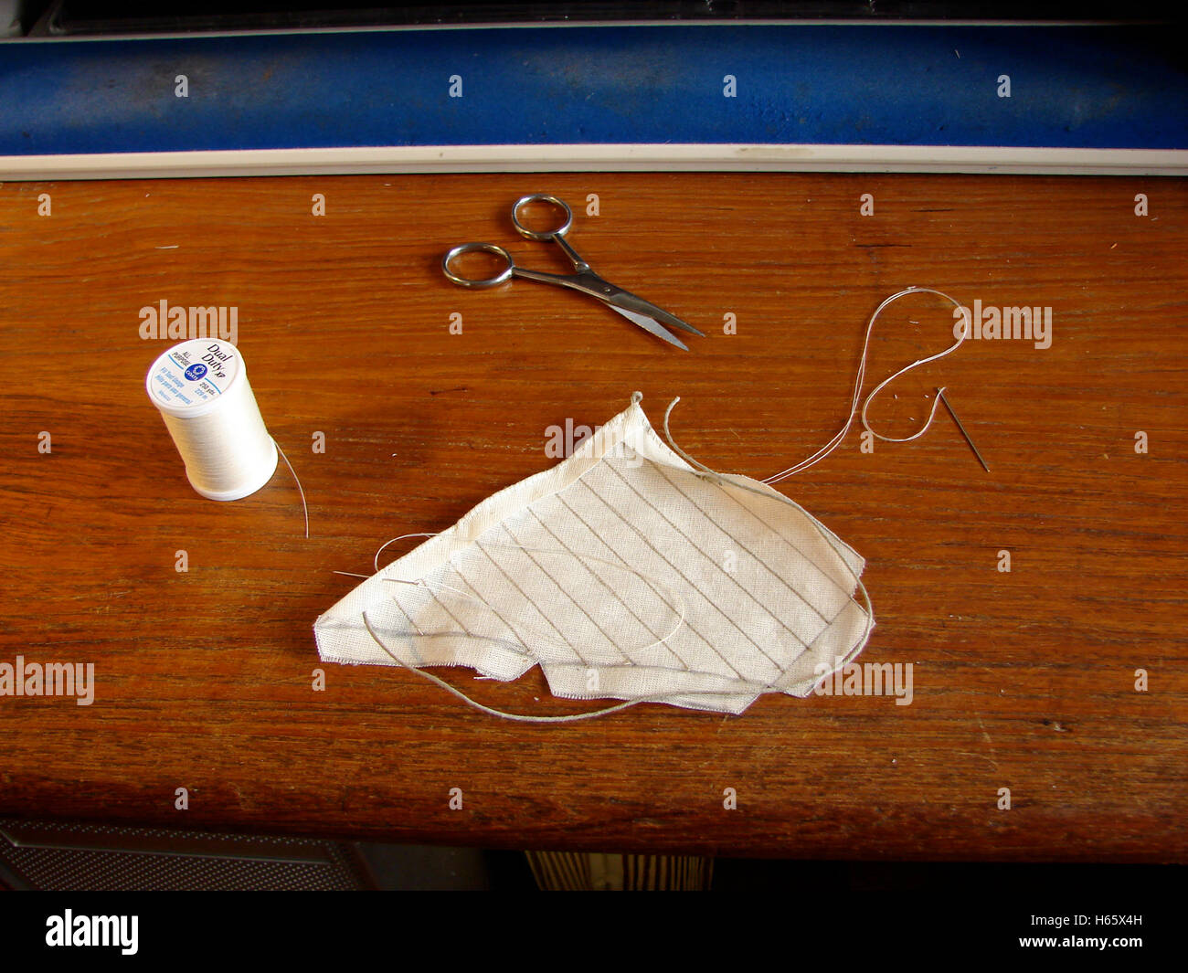 Sail being sewn for a model ship Stock Photo - Alamy