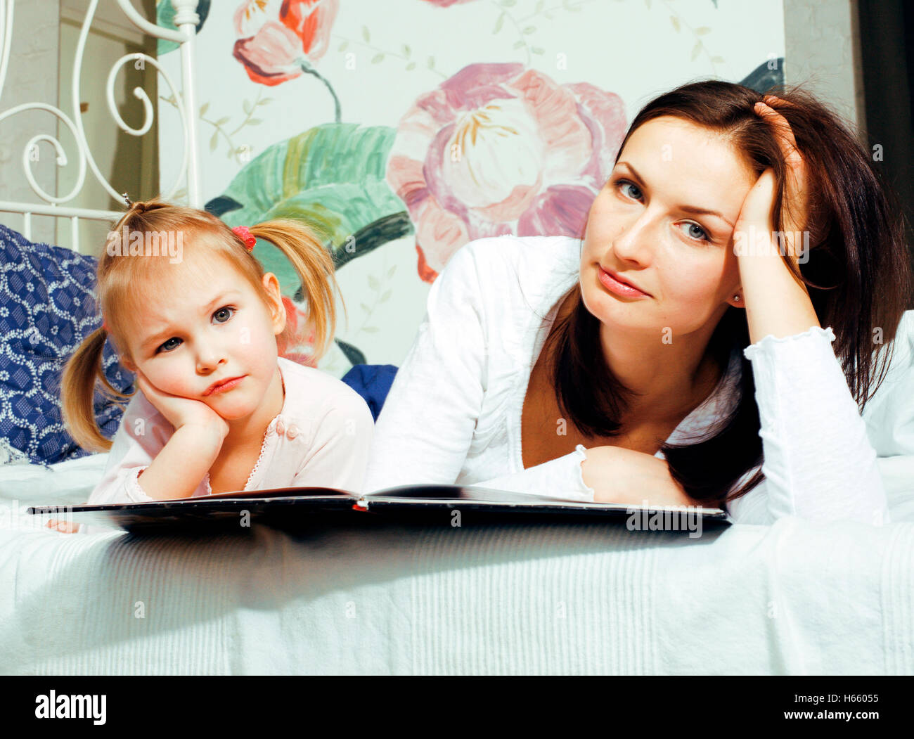 mother with daughter together in bed smiling, happy family close up ...