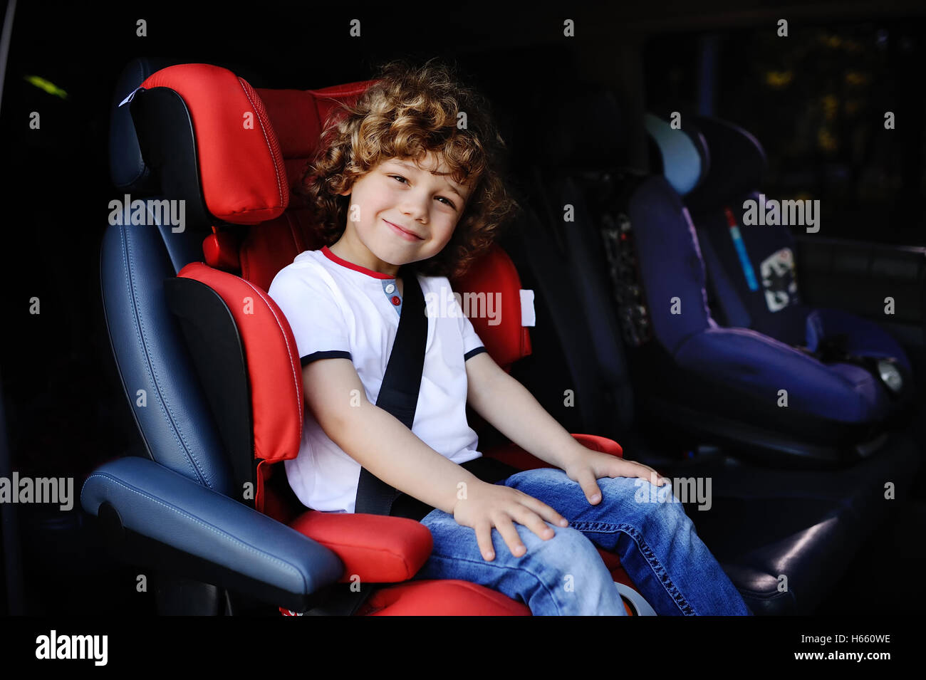 baby boy sitting in a red child car seat Stock Photo - Alamy