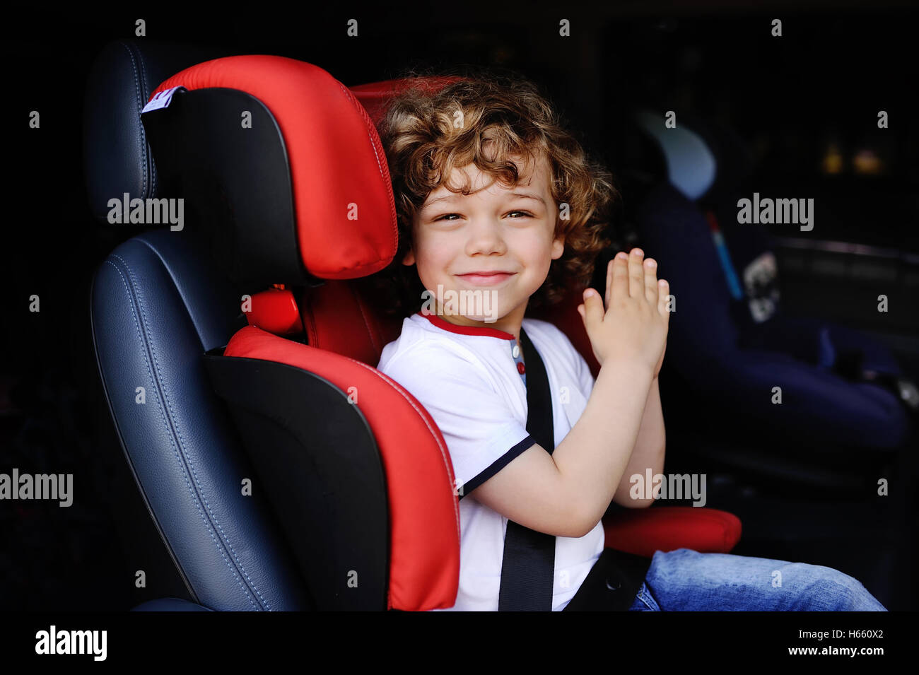 baby boy sitting in a red child car seat Stock Photo - Alamy