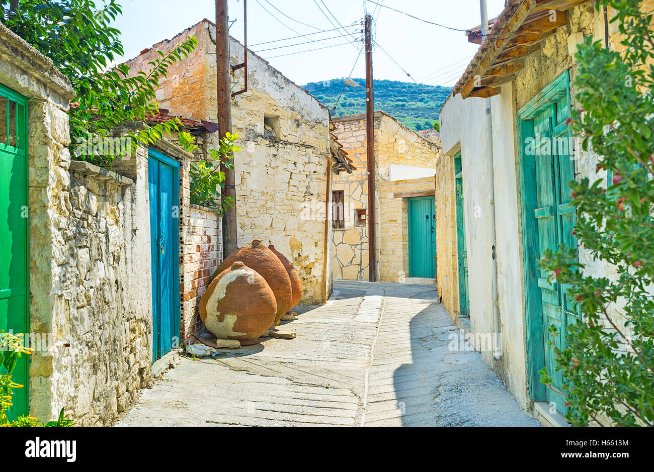 The narrow street with the small stone houses, colorful wooden doors ...