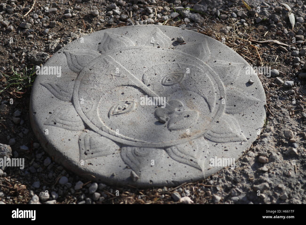 Decorative sun face paving stone in a walking path Stock Photo - Alamy