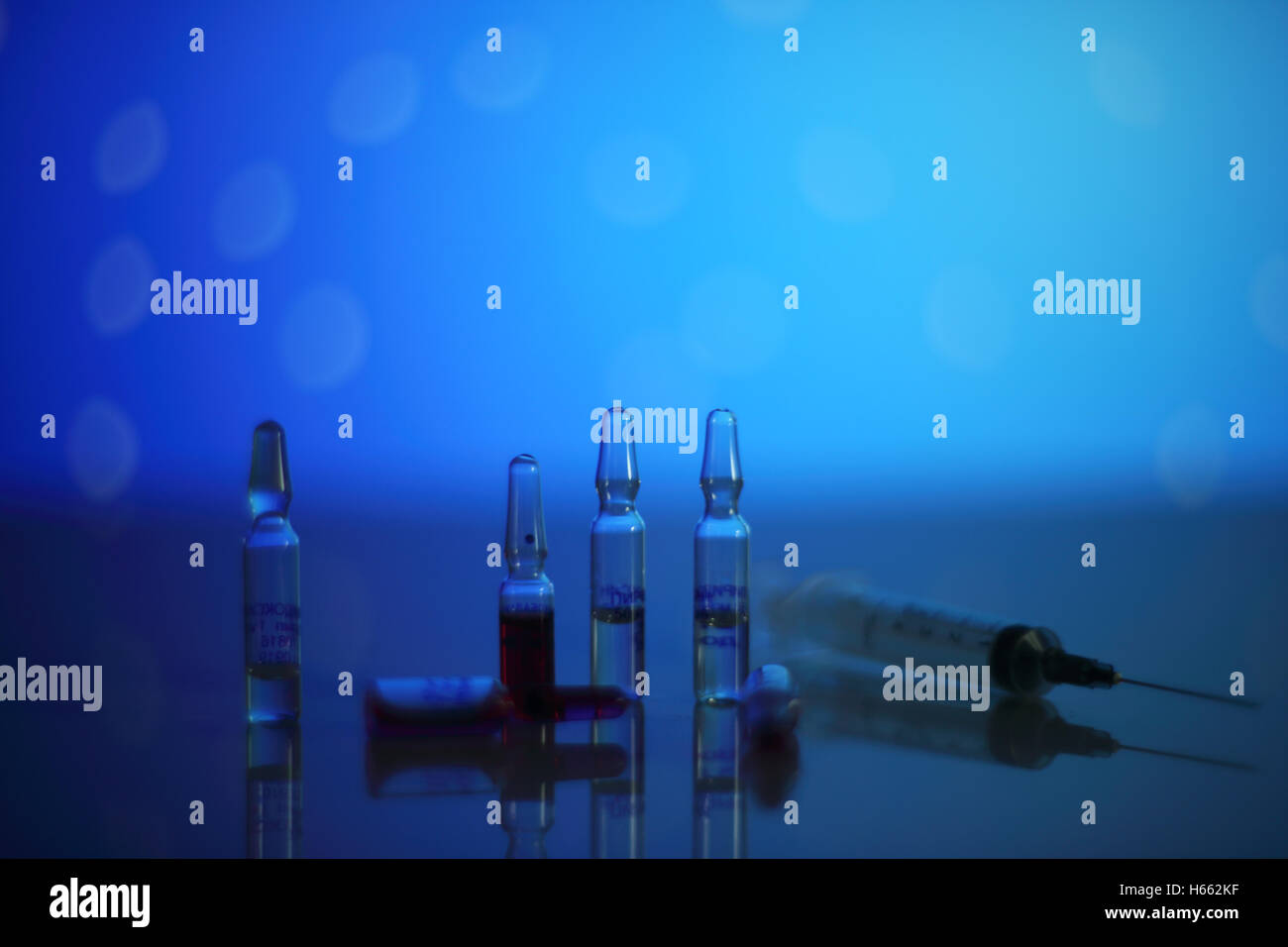 Syringe and ampoules on glowing blue reanimation light background Stock ...