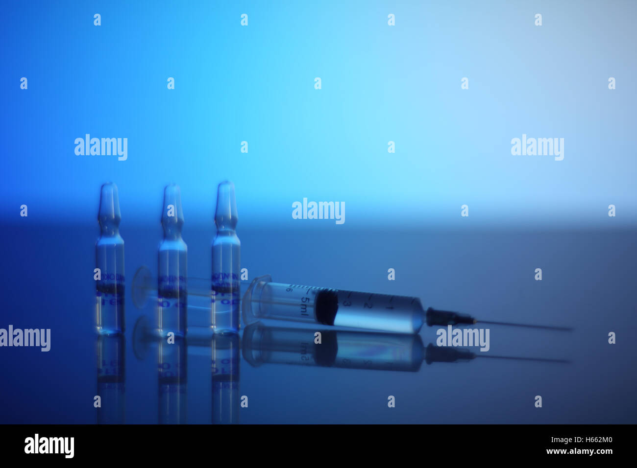 Syringe and ampoules on glowing blue reanimation light background Stock ...