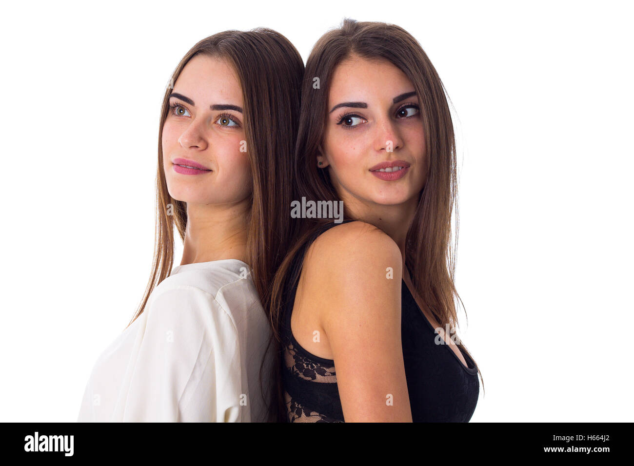 Two young woman standing back to back Stock Photo - Alamy