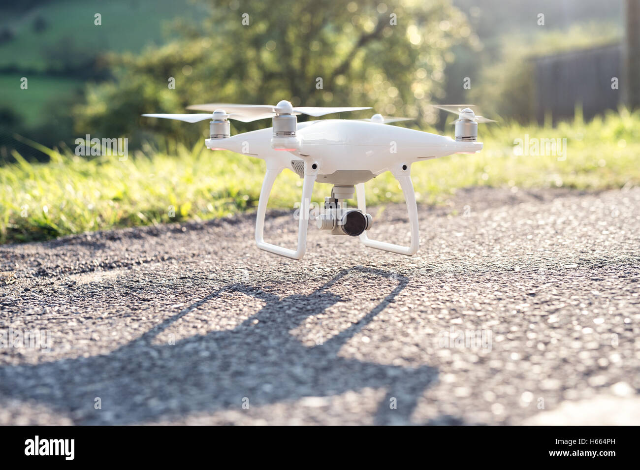 Flying helicopter drone with camera. Green sunny nature Stock Photo - Alamy