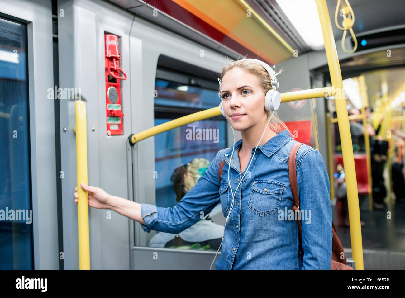 Beautiful young woman with headphones in subway train Stock Photo - Alamy