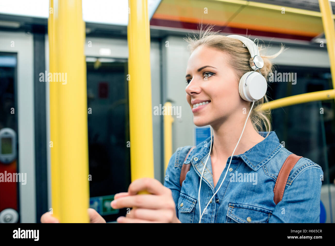 Beautiful young woman with headphones in subway train Stock Photo - Alamy