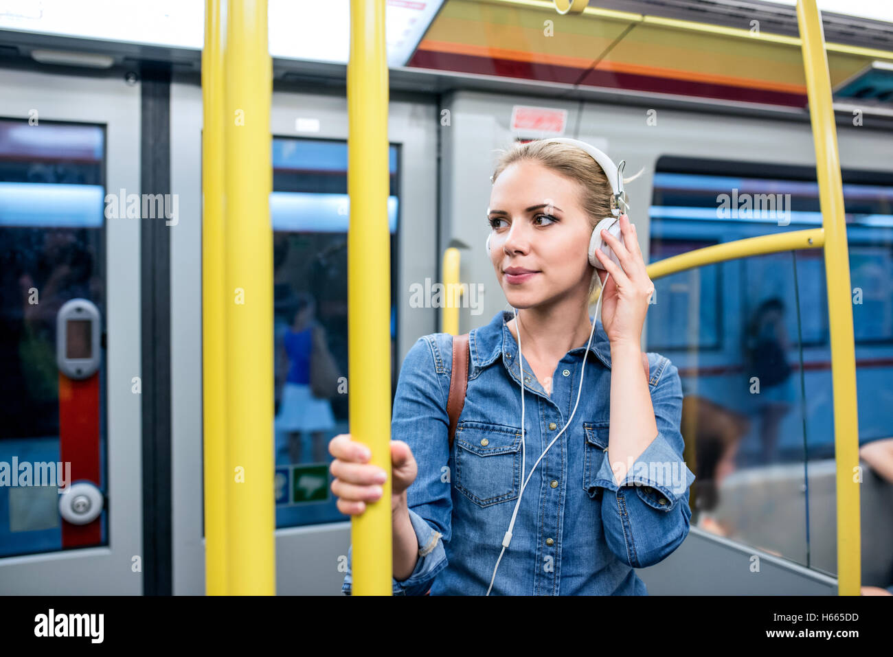 Beautiful young woman with headphones in subway train Stock Photo - Alamy