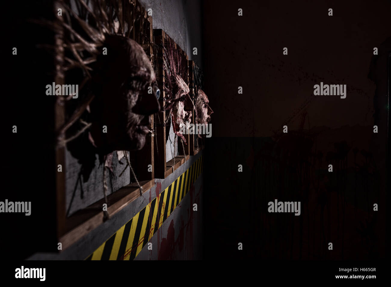 Dismembered ghastly faces stuck in square frames above yellow and black ...