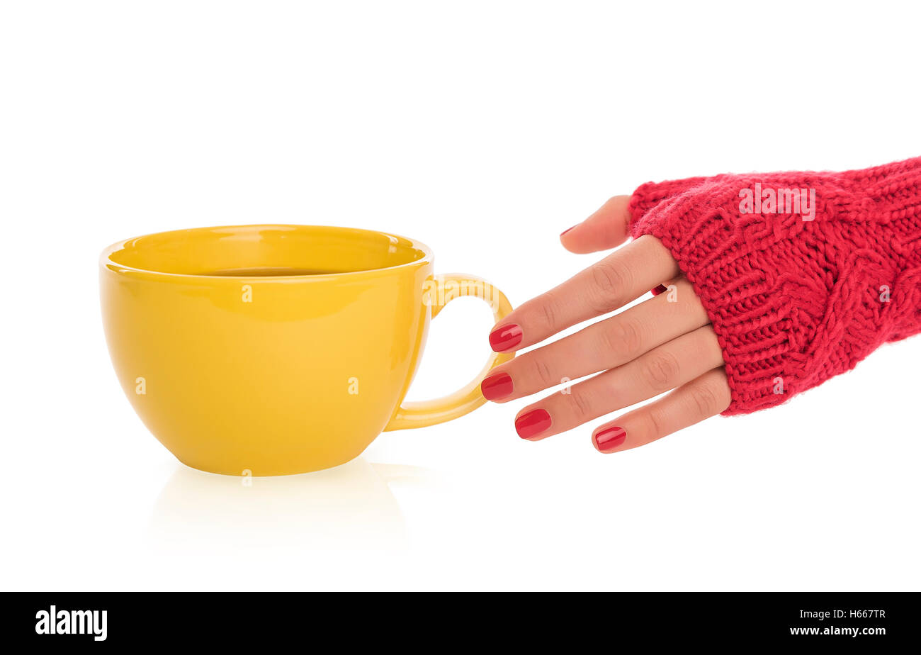 Female hand in a mitten reaches for a cup of tea on a white background ...