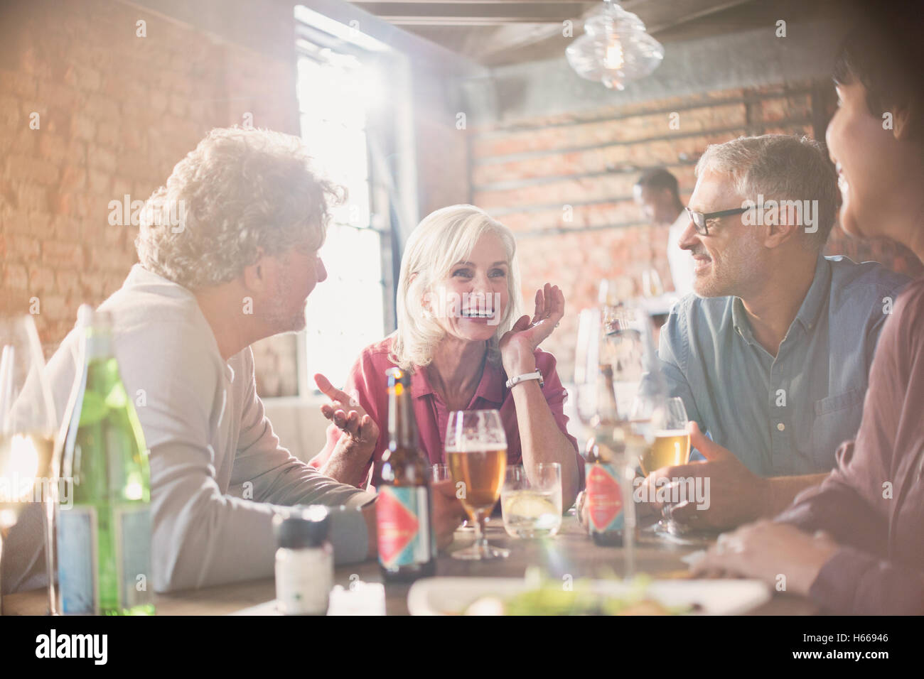 Couples talking and drinking beer at restaurant table Stock Photo - Alamy