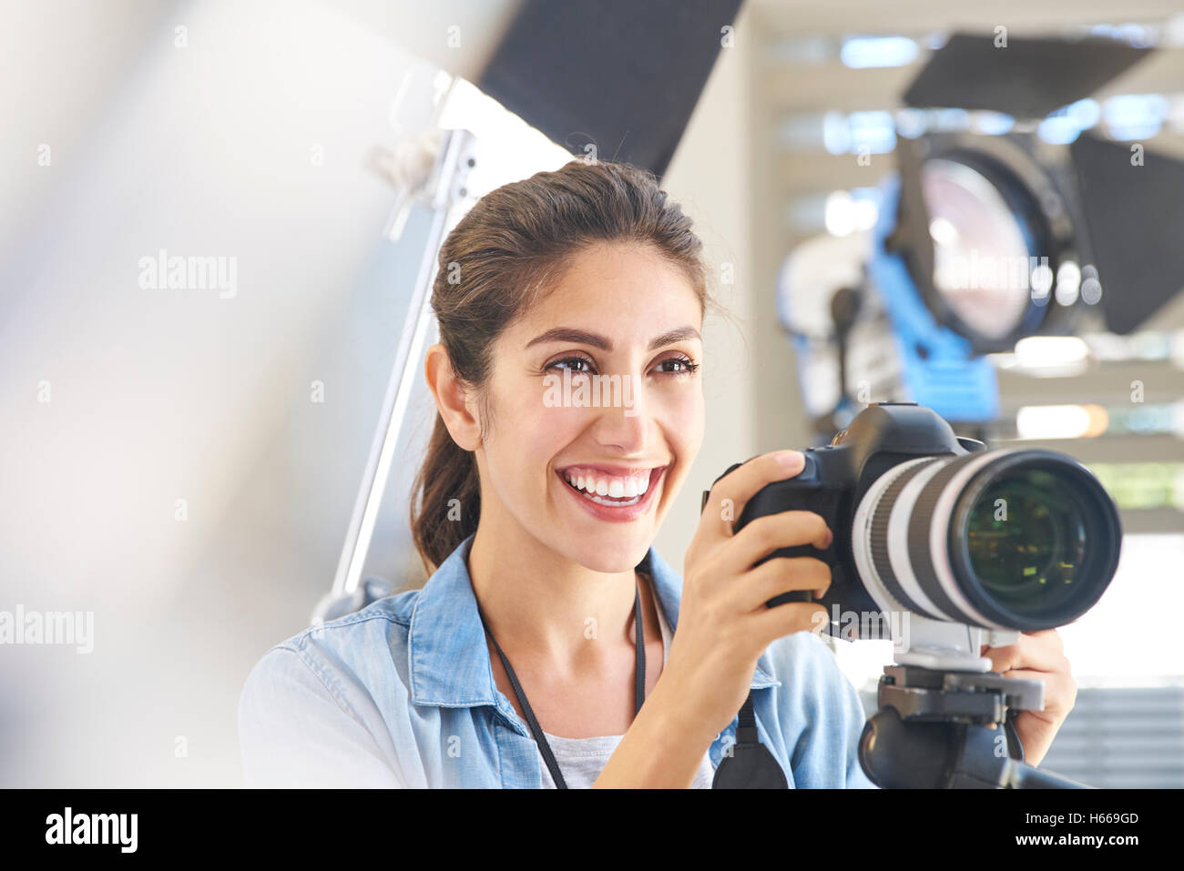 Smiling female photographer behind camera in studio Stock Photo - Alamy