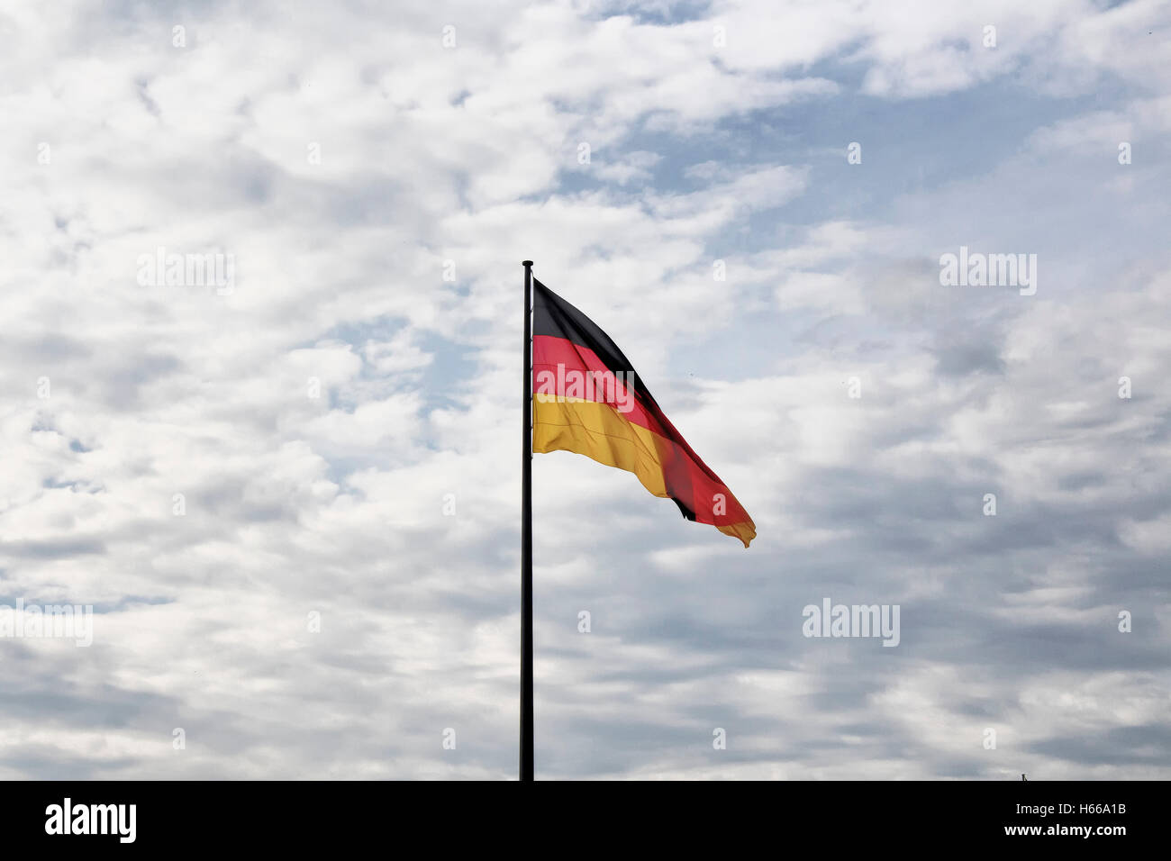 German flag waves with cloudy sky background in front of Reichstag ...