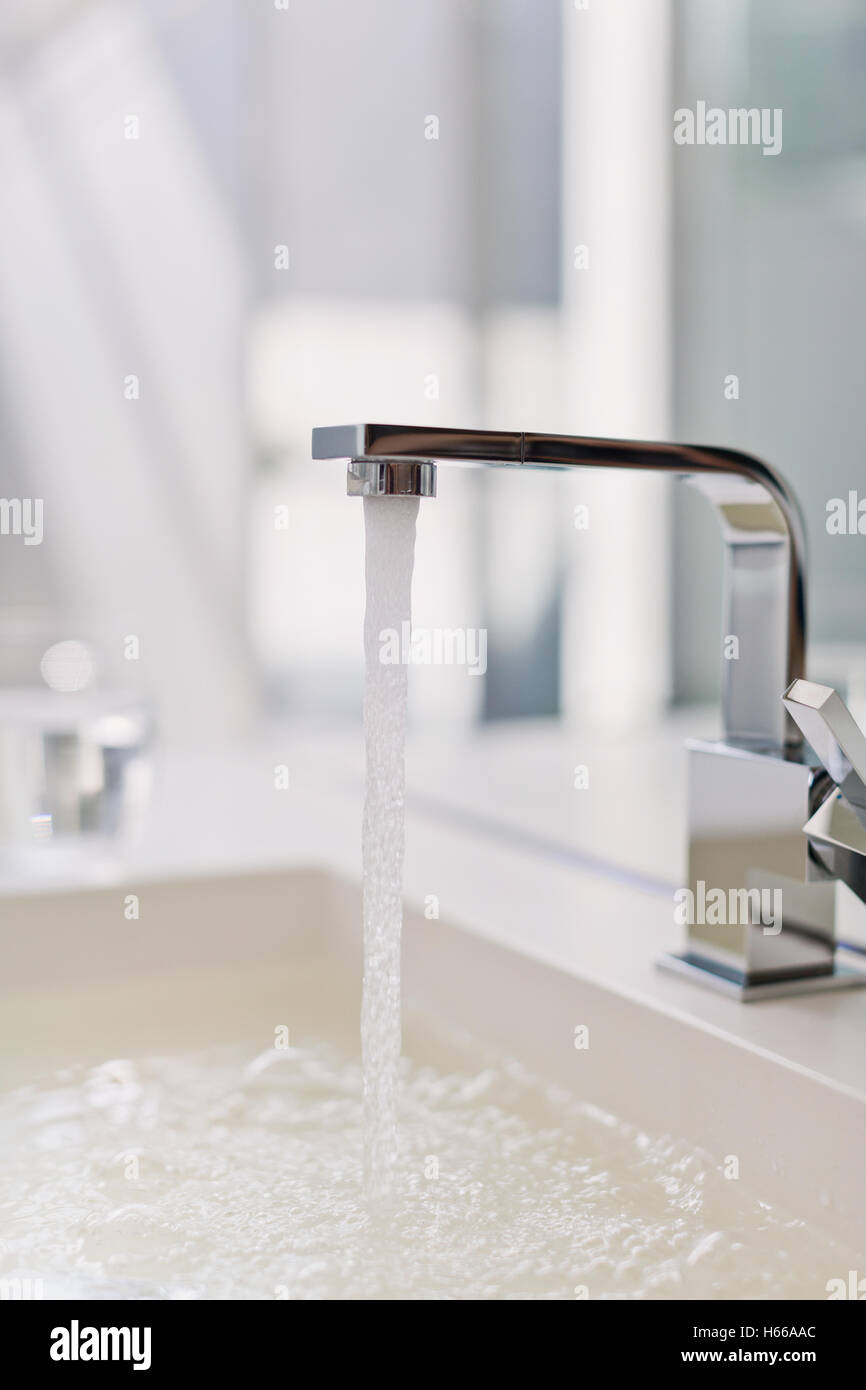 Water from modern faucet filling bathroom sink Stock Photo - Alamy