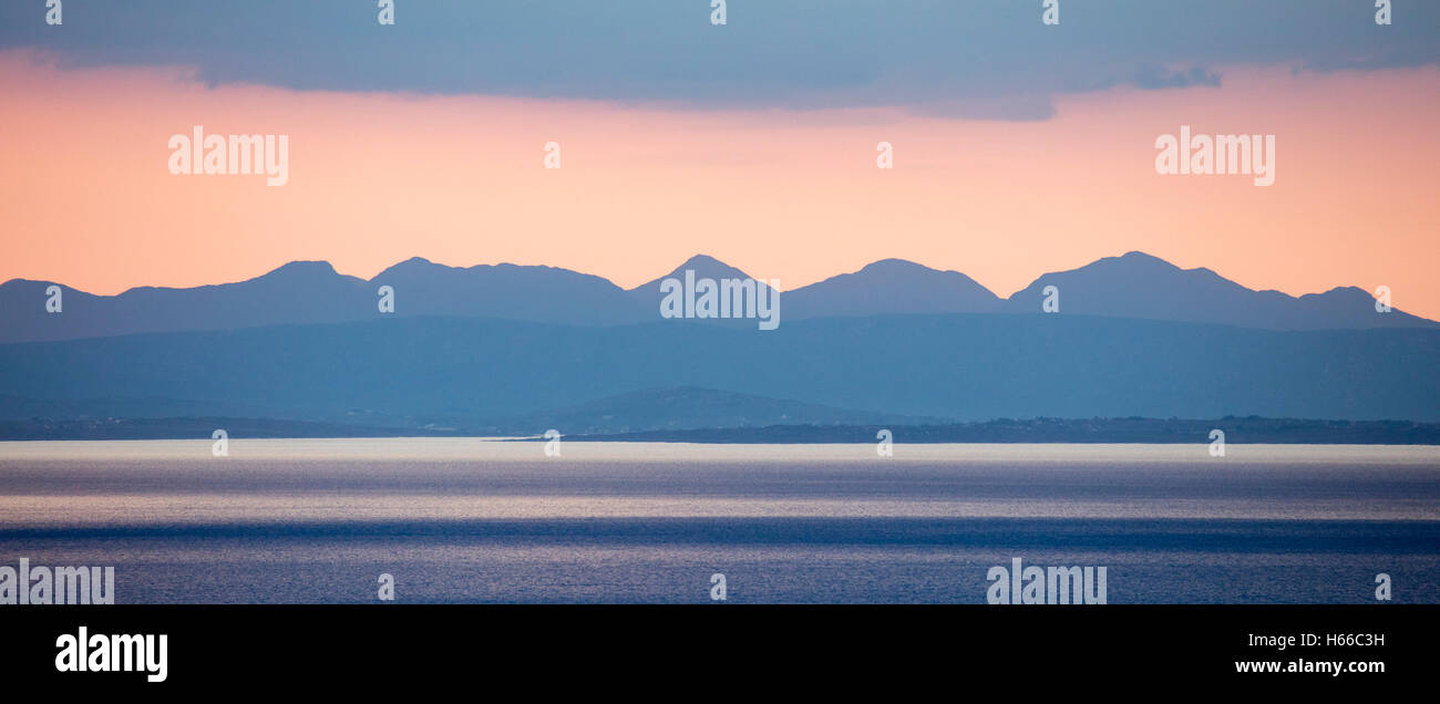 Sunset view of the Twelve Bens rising across Galway Bay, County Clare ...