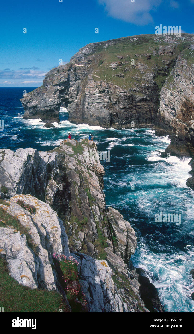 Couple on the cliff overlooking Marble Arch, Horn Head, County Donegal ...