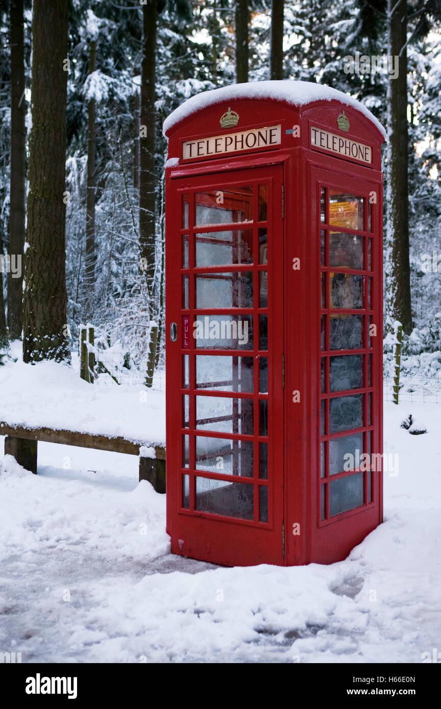 An old british red telephone box stands alone in a snowy landscape ...