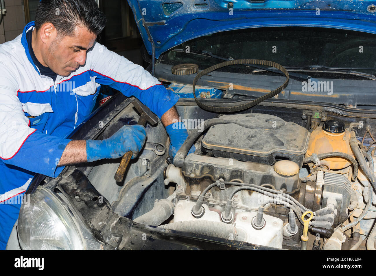 Car mechanic fixing an engine in his garage. copy space Stock Photo - Alamy