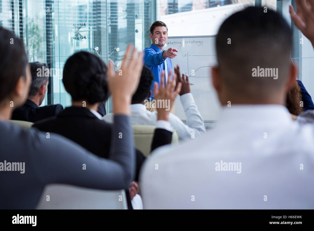 Colleagues raising their hands during meeting Stock Photo - Alamy