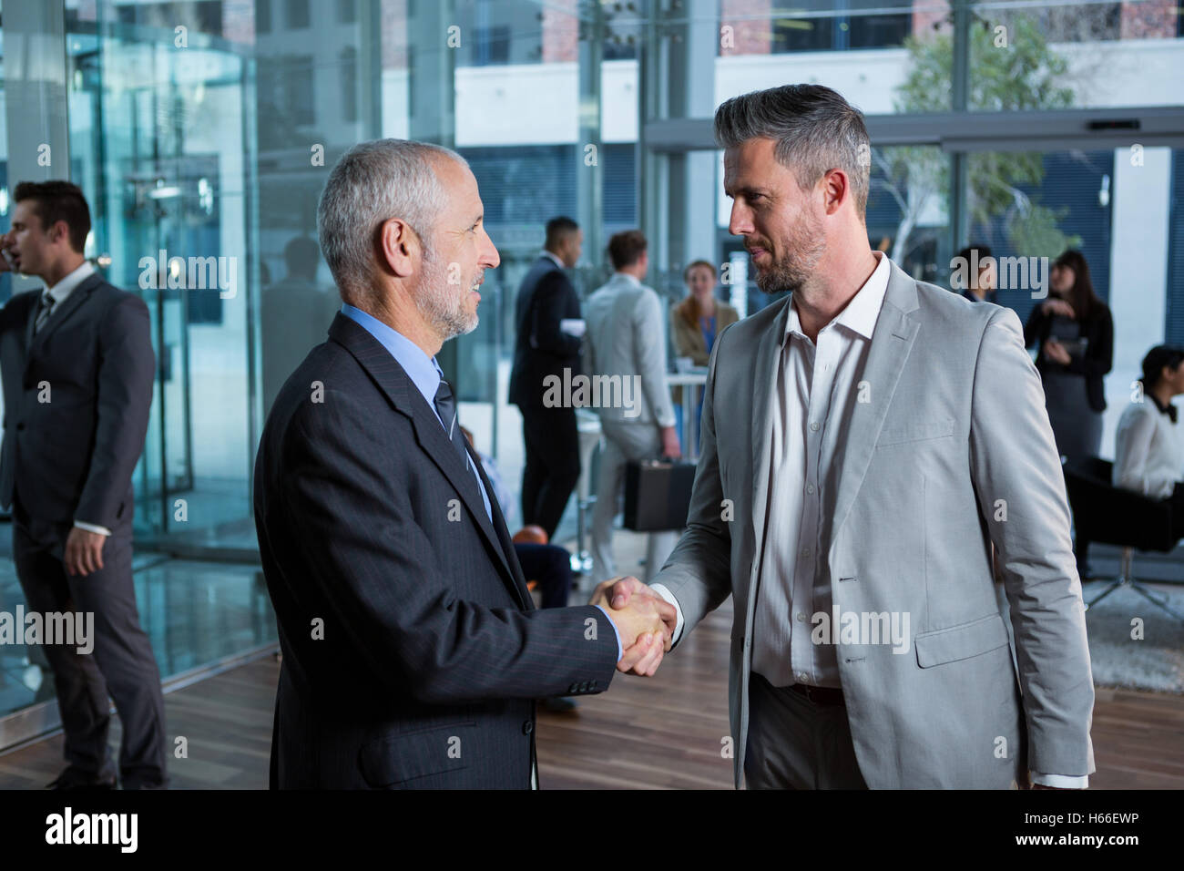 Standing greeting shaking hands smiling leadership face to face hi-res ...