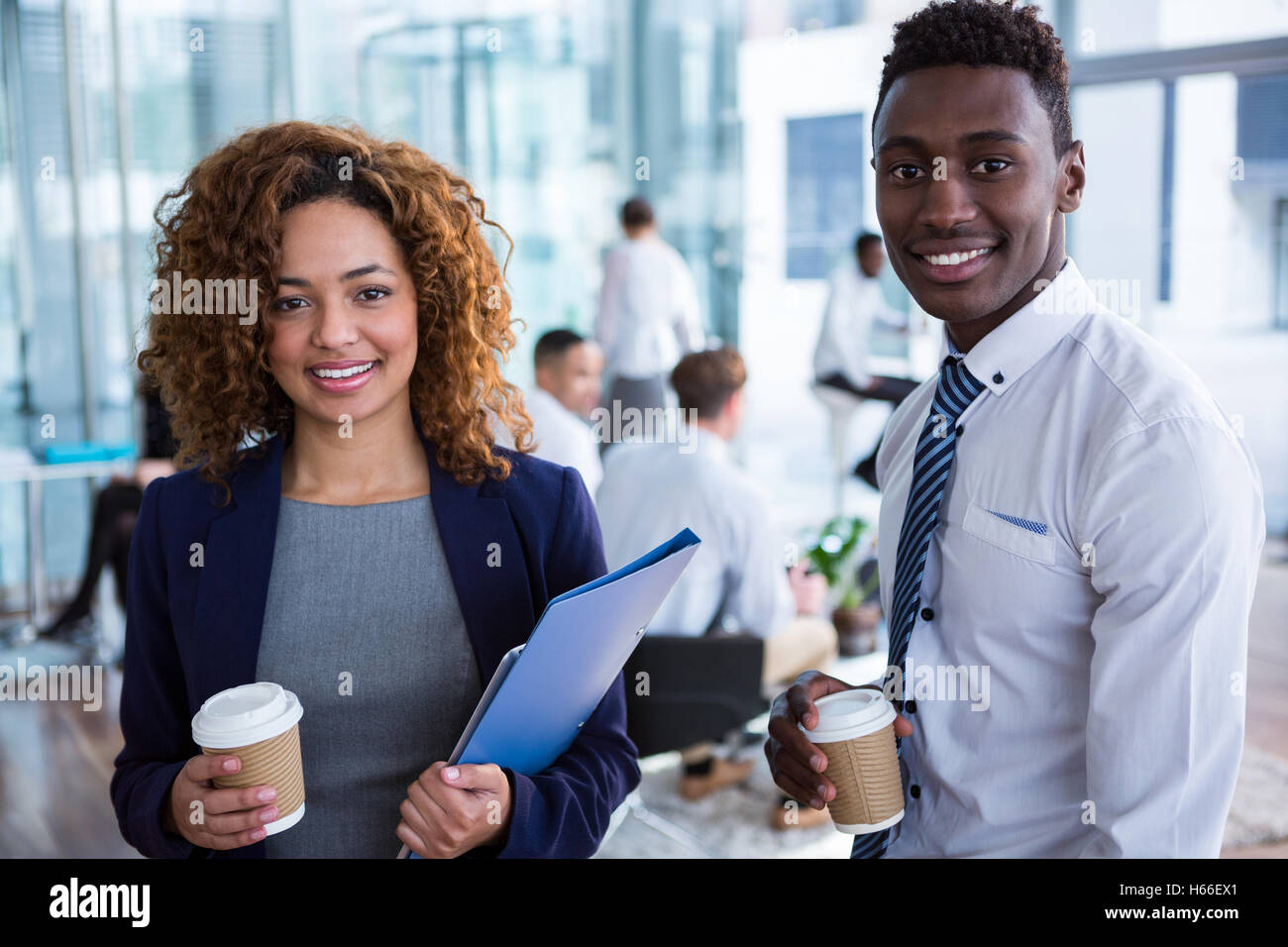 Smiling business colleagues having coffee in office Stock Photo - Alamy