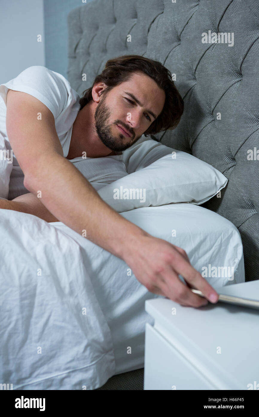 Man waking up with mobile alarm clock Stock Photo - Alamy